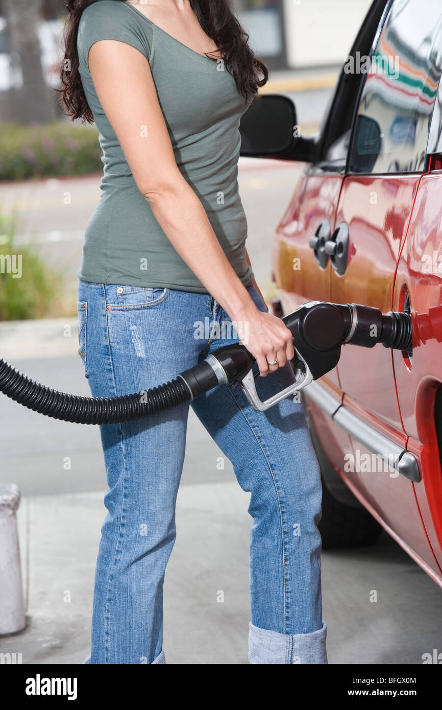 Woman by car with fuel pump Stock Photo - Alamy