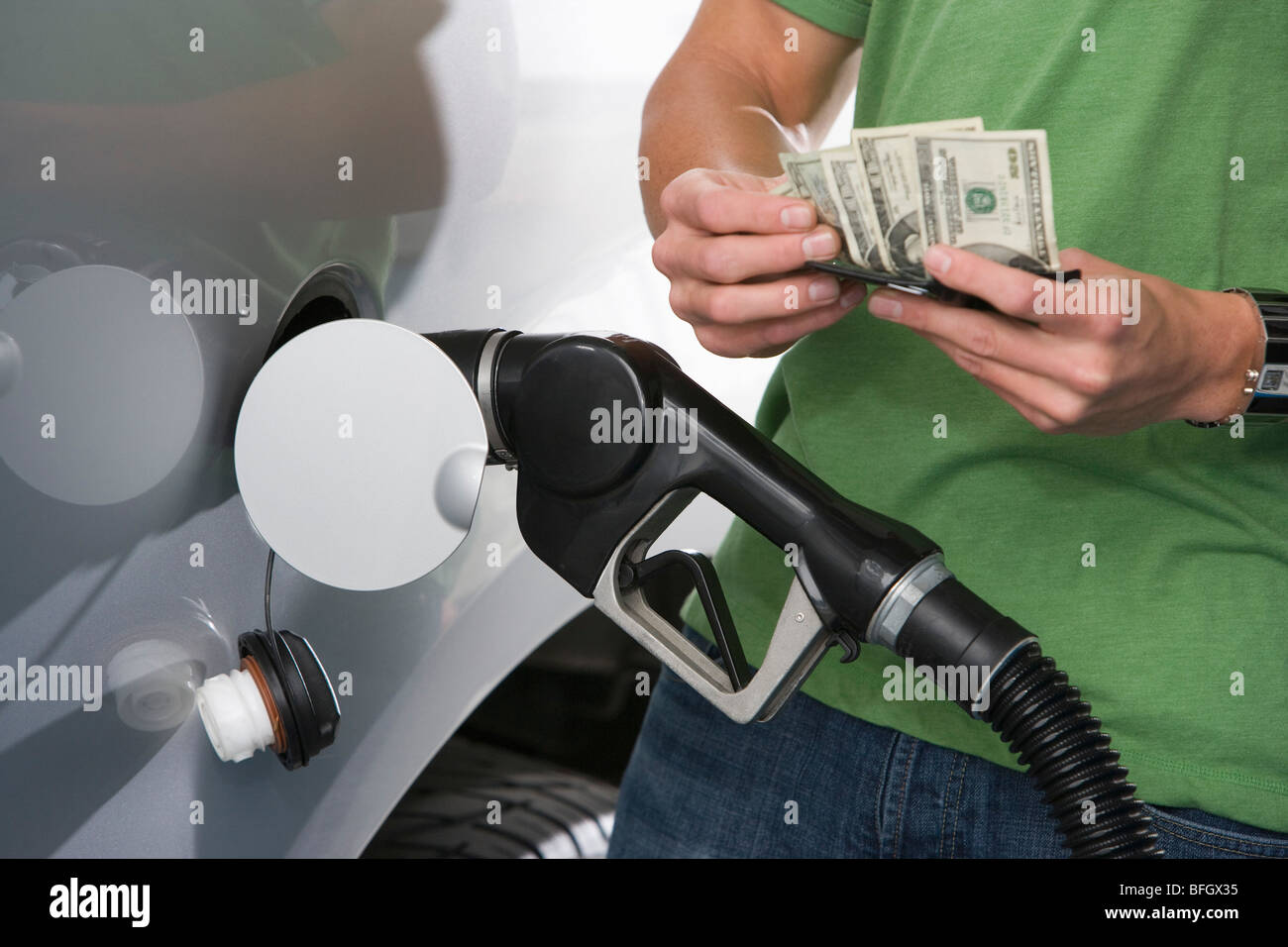 Man at service station, counting money Stock Photo - Alamy