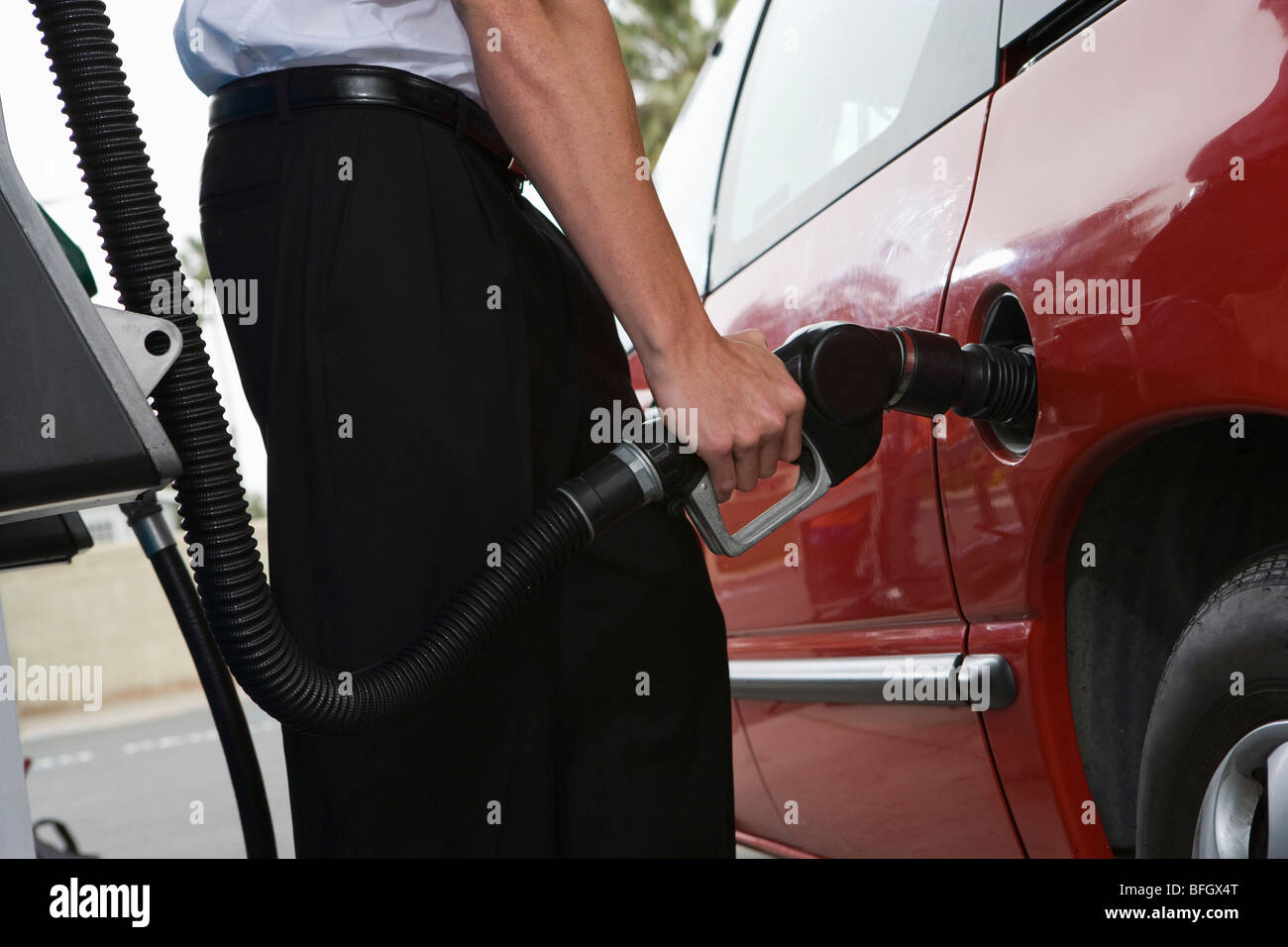 Young man with fuel pump, mid section Stock Photo - Alamy
