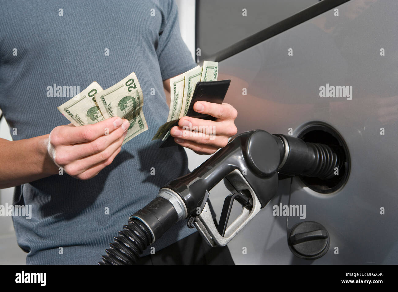 Man at service station, counting money Stock Photo - Alamy
