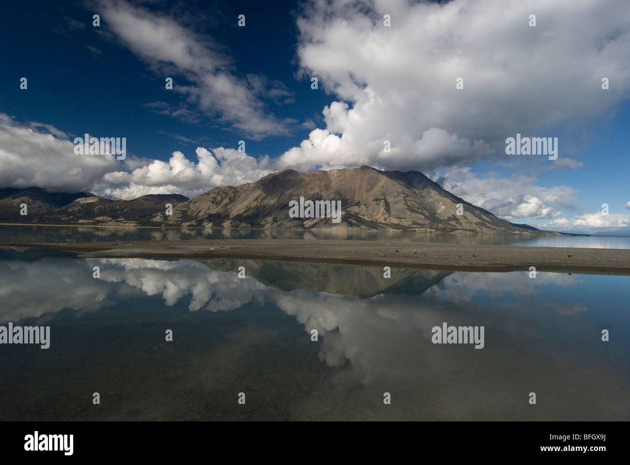 Kluane Lake and Sheep Mountain with cumulus clouds reflected in lake ...