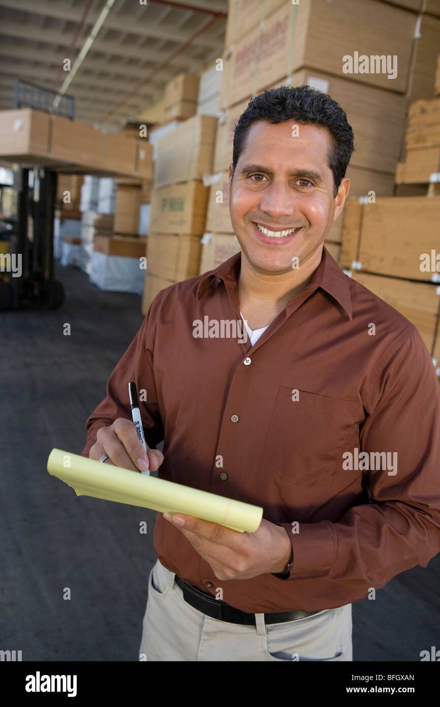 Mid-adult man stock-taking in warehouse Stock Photo - Alamy