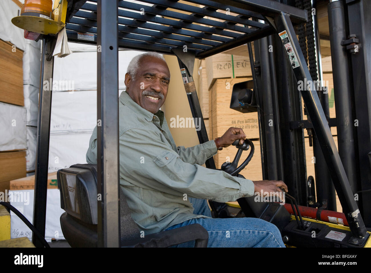 Senior man driving forklift truck Stock Photo - Alamy