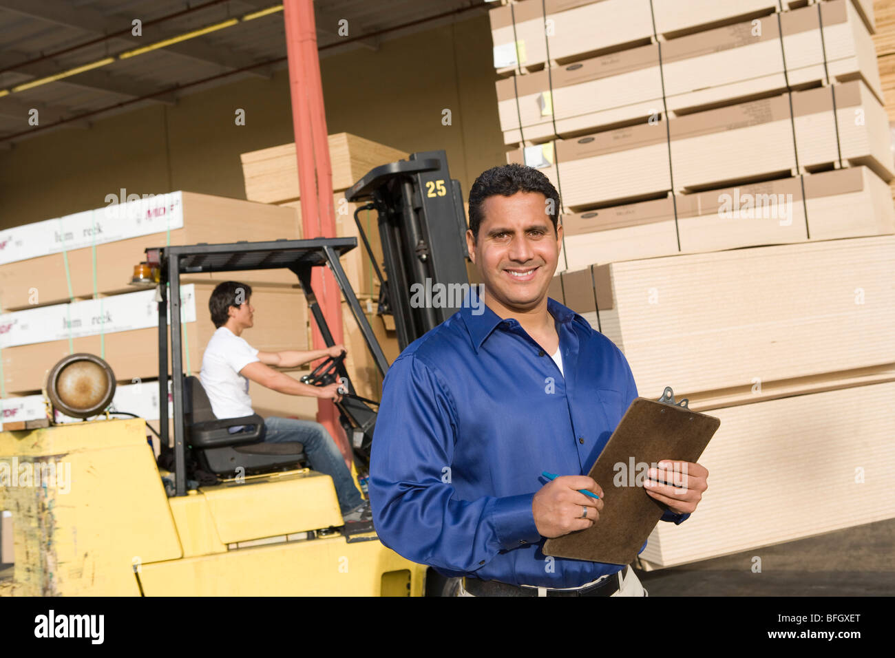 Warehouseman and forklift truck driver Stock Photo - Alamy
