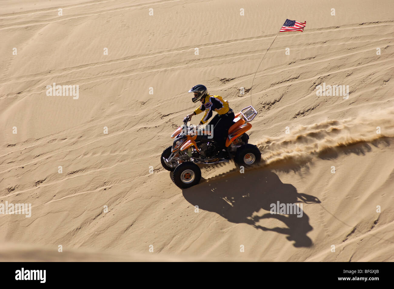 Young Man Riding ATV Over Sand Dune Stock Photo - Alamy