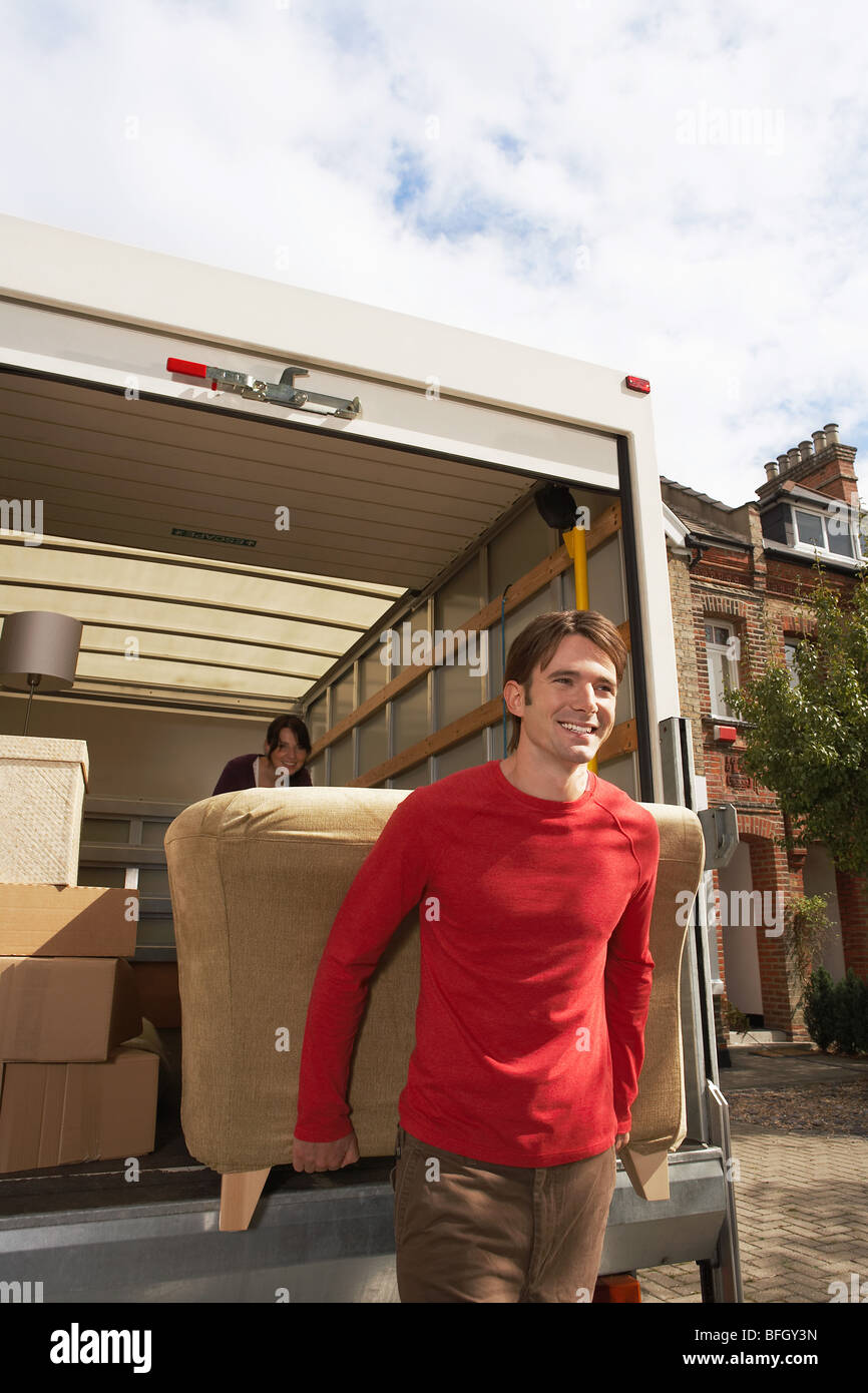 Moving Couple Carrying Sofa Stock Photo - Alamy