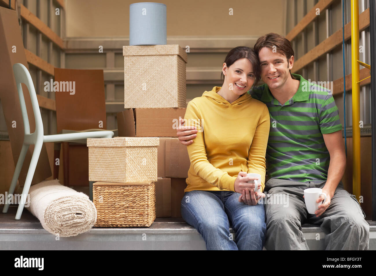 Couple Sitting in Back of Moving Van Stock Photo - Alamy
