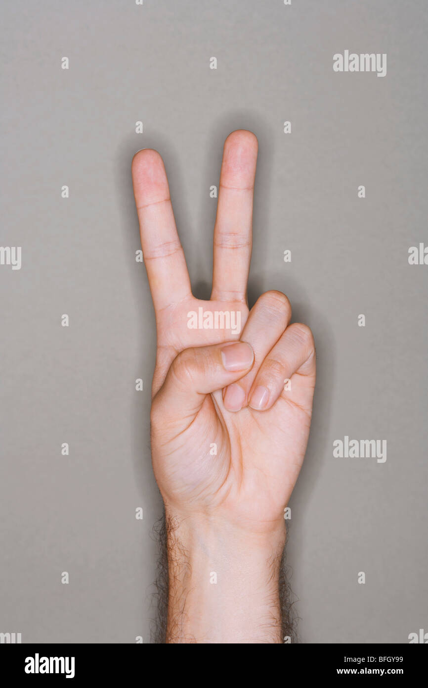 Man making victory sign, close-up on hand Stock Photo - Alamy