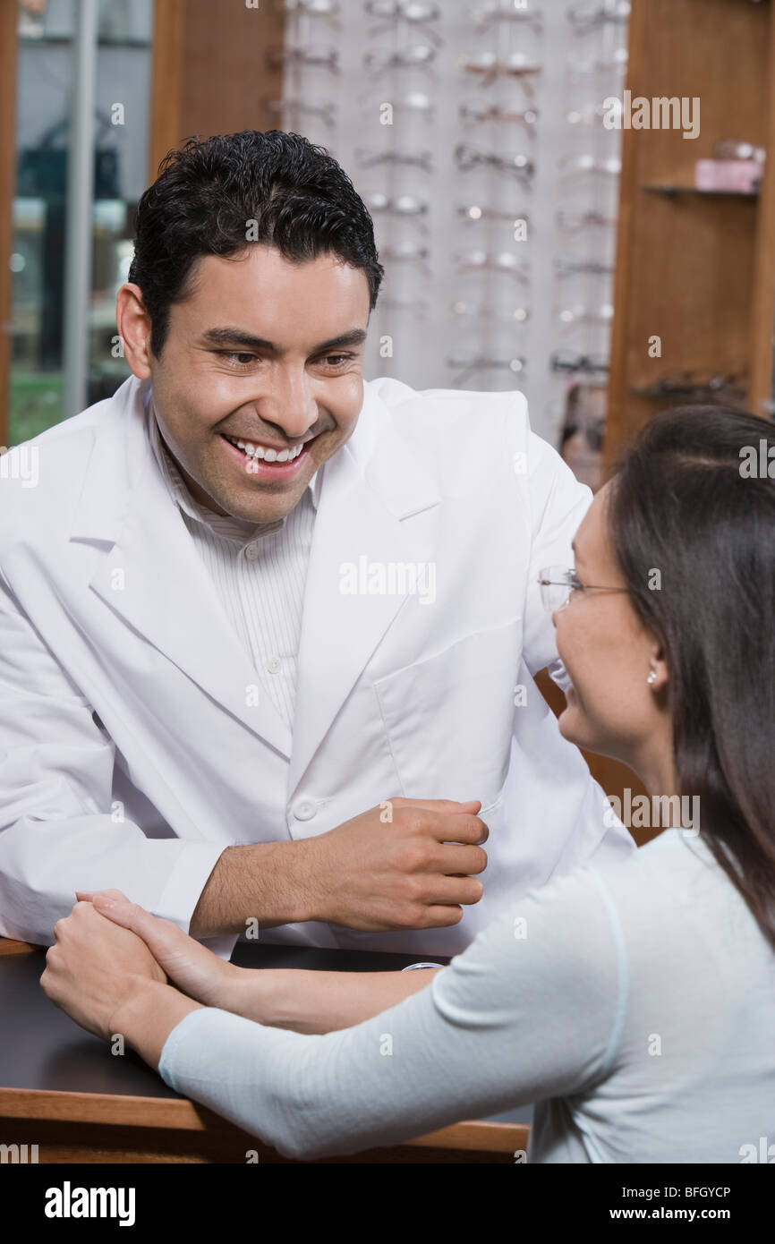 Optician helping customer Stock Photo - Alamy