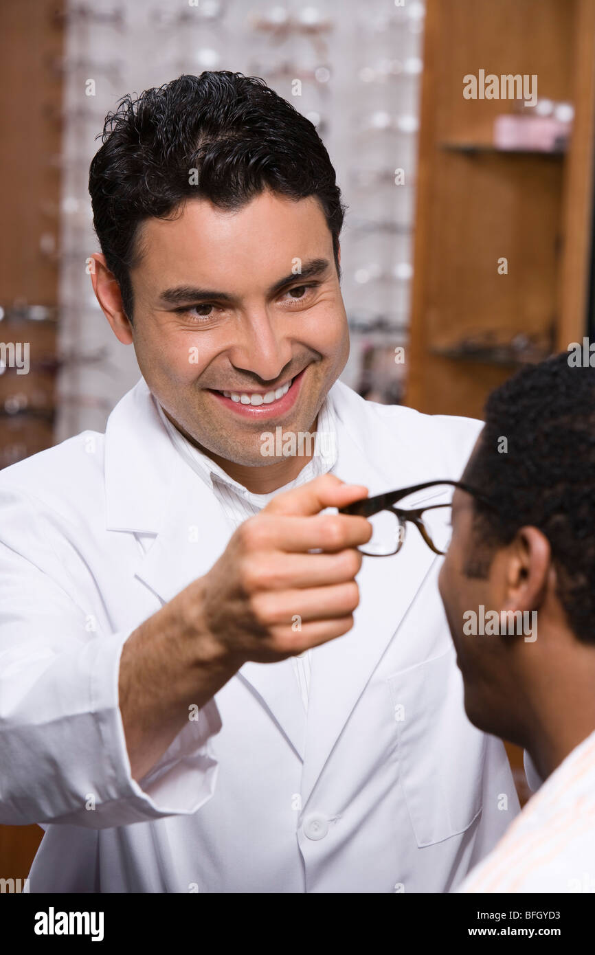 Optician helping customer Stock Photo - Alamy