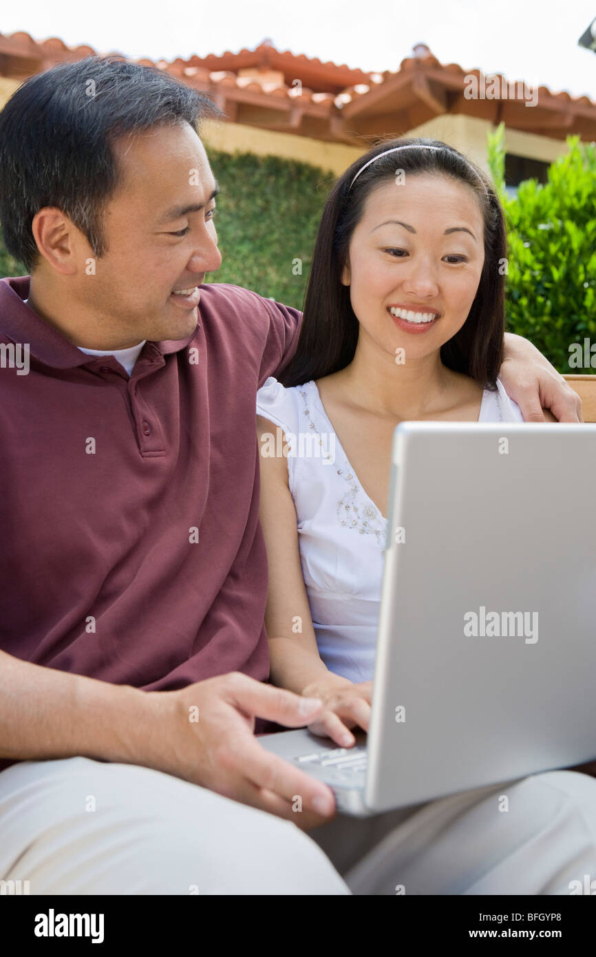 Couple using laptop in back yard Stock Photo - Alamy