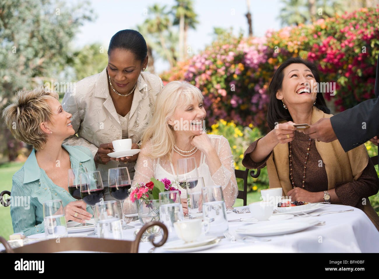 Female friends drinking at outdoor table Stock Photo - Alamy
