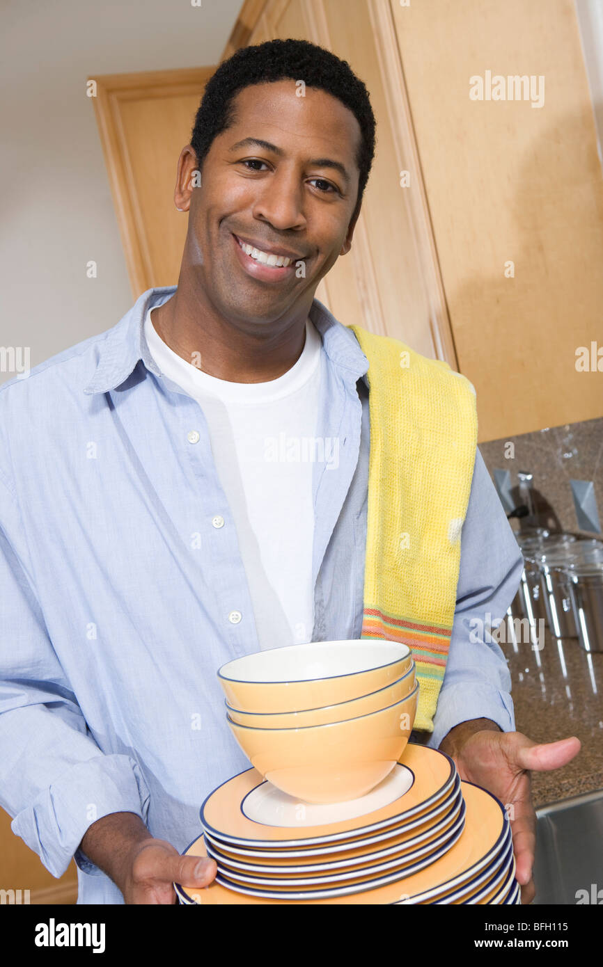 Man with stack of dishes Stock Photo - Alamy