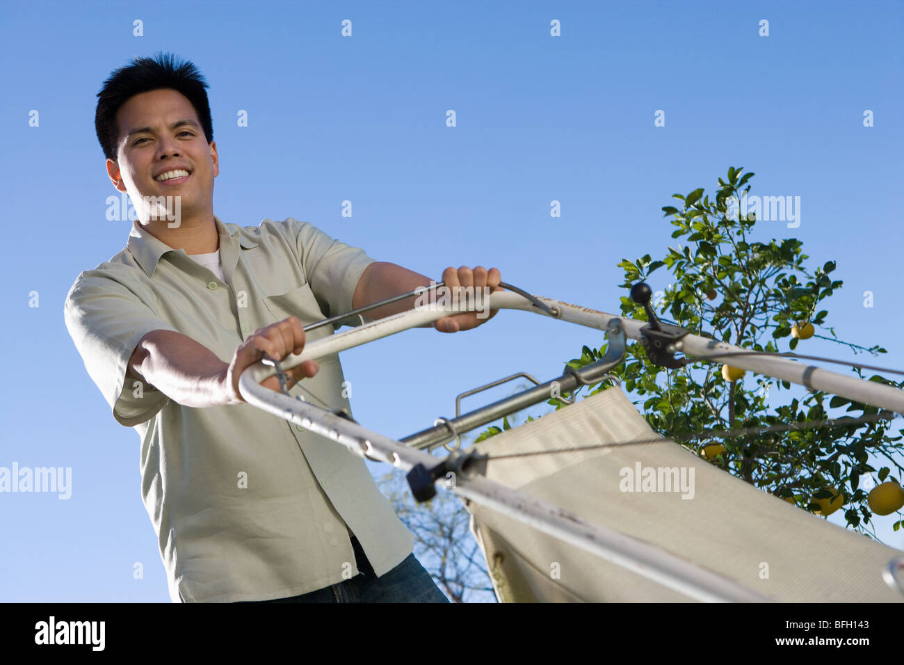 Man with lawnmower Stock Photo - Alamy