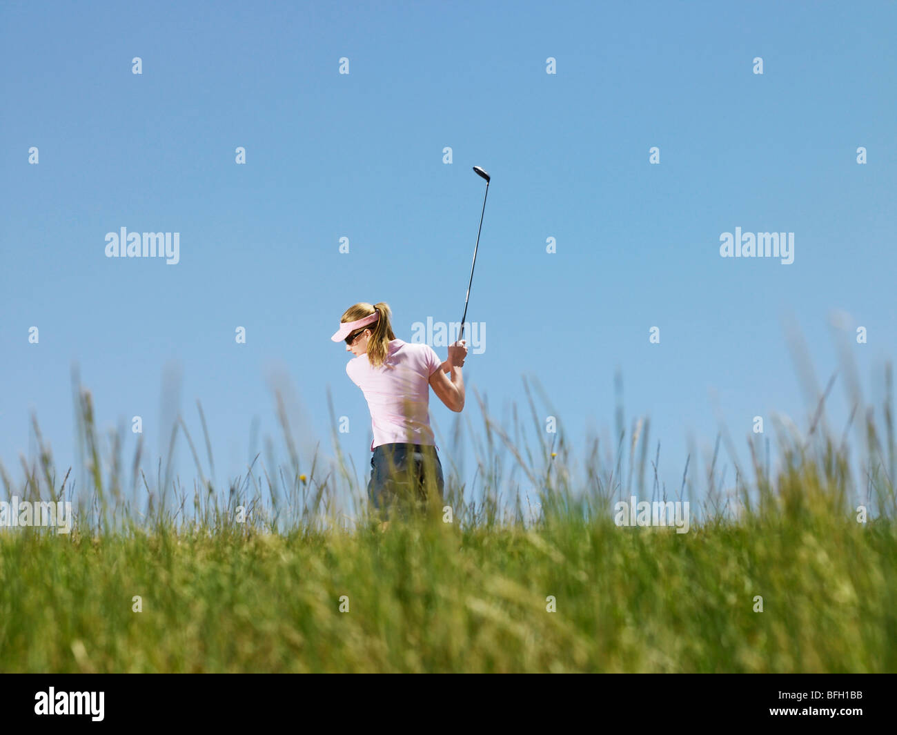 Young female golfer driving ball, back view Stock Photo - Alamy