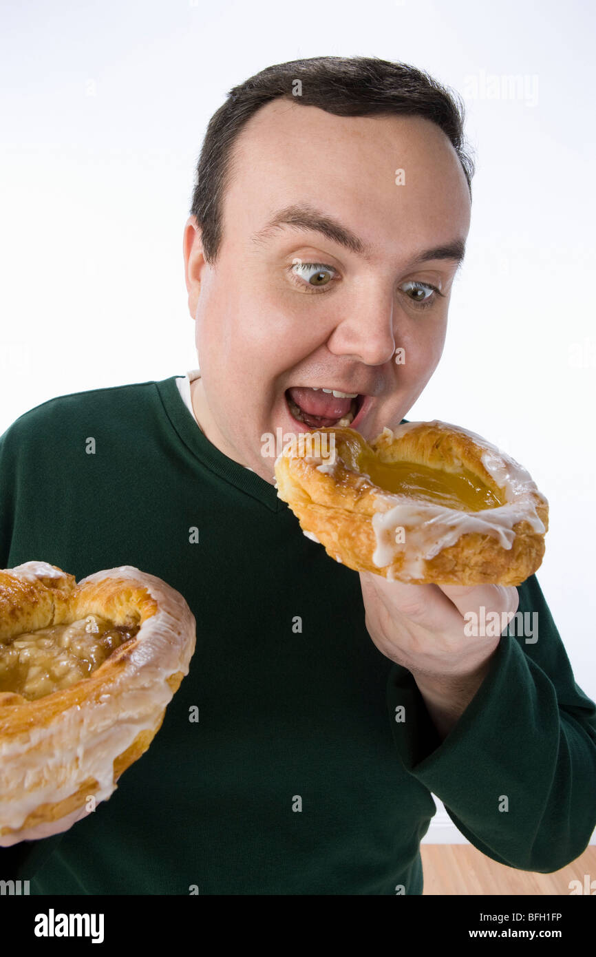 Overweight mid-adult man eating pastry Stock Photo - Alamy