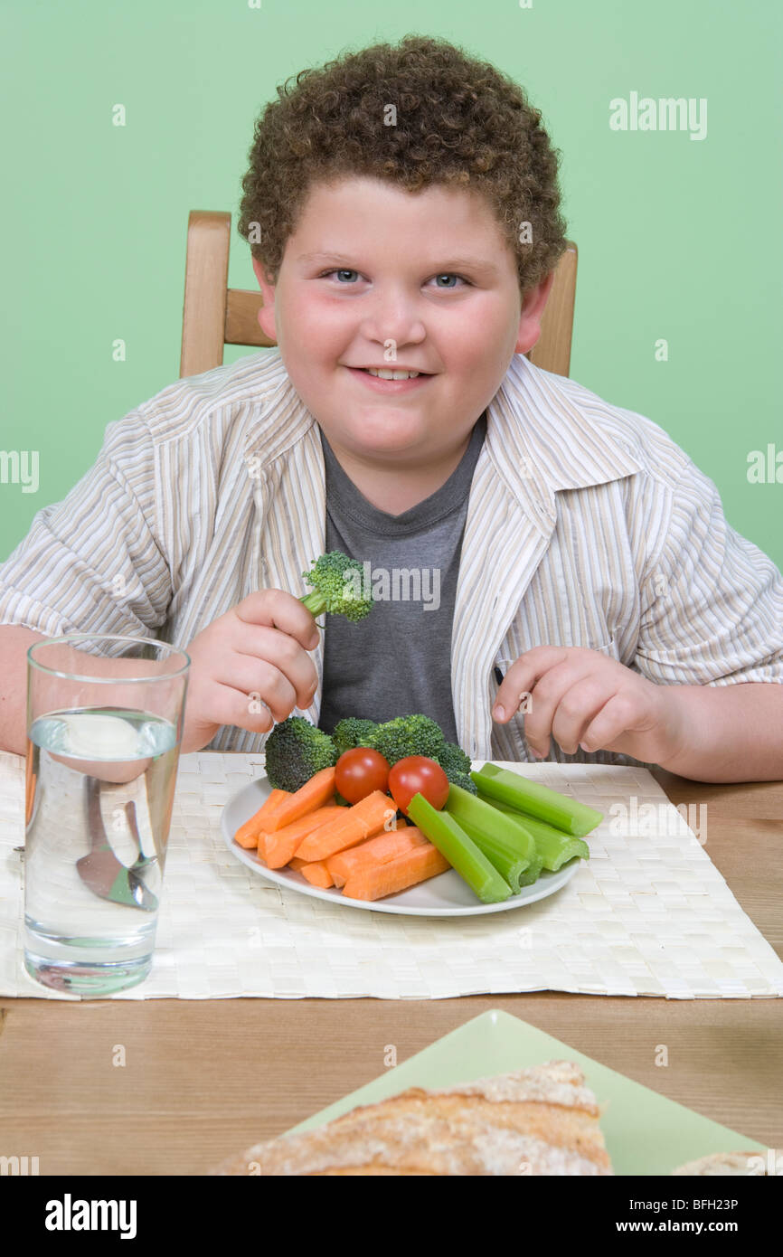 Overweight boy having healthy meal Stock Photo - Alamy
