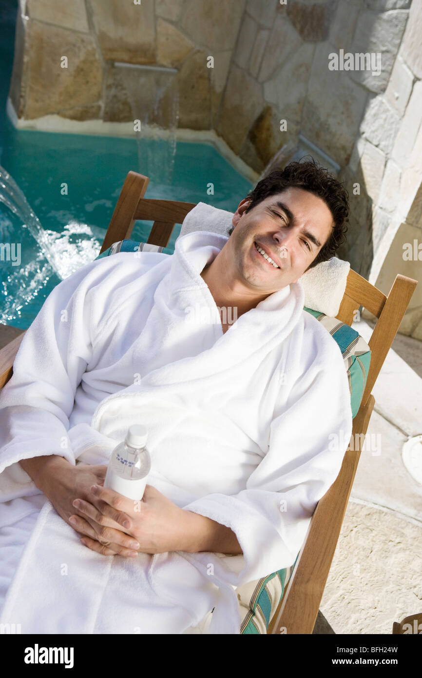 Portrait of man relaxing by swimming pool Stock Photo - Alamy