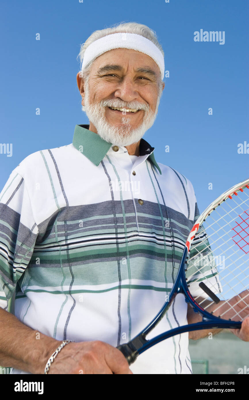 Senior man holding tennis racket, portrait Stock Photo - Alamy