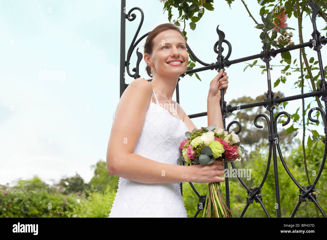 Standing looking away smiling holding bouquet hi-res stock photography ...