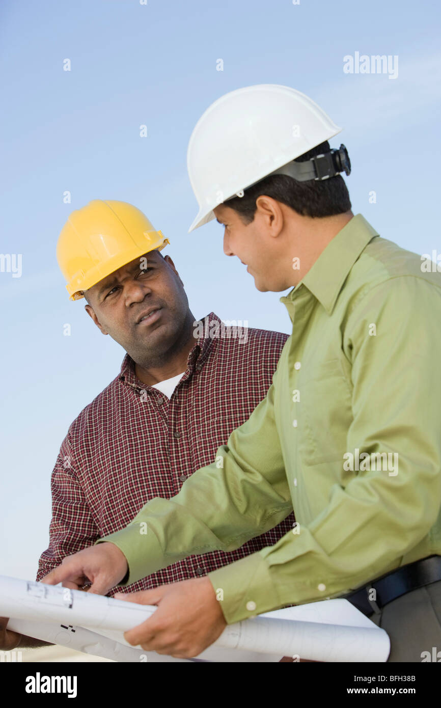 Construction workers studying blueprints outdoors Stock Photo - Alamy