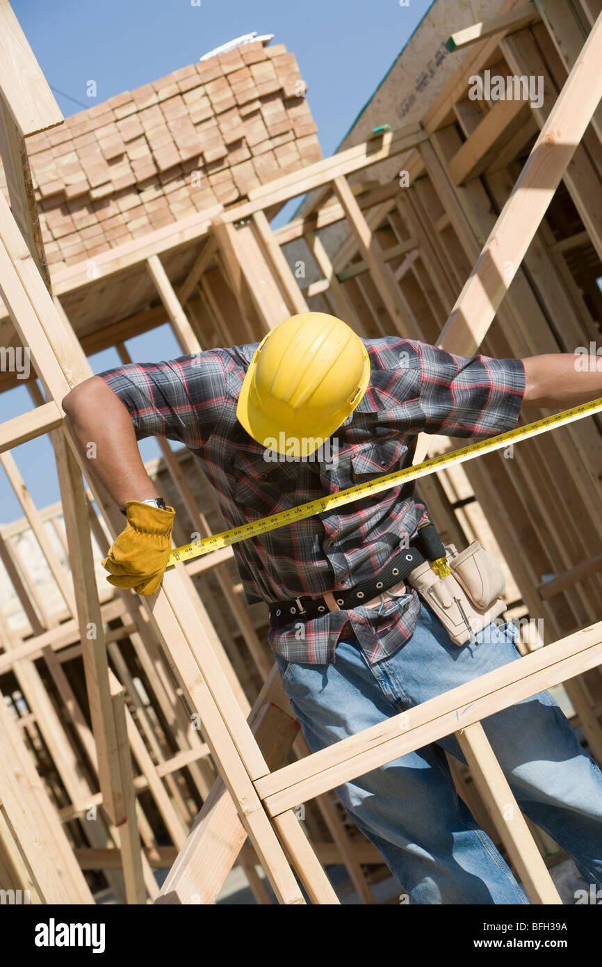 Construction worker measuring building Stock Photo - Alamy
