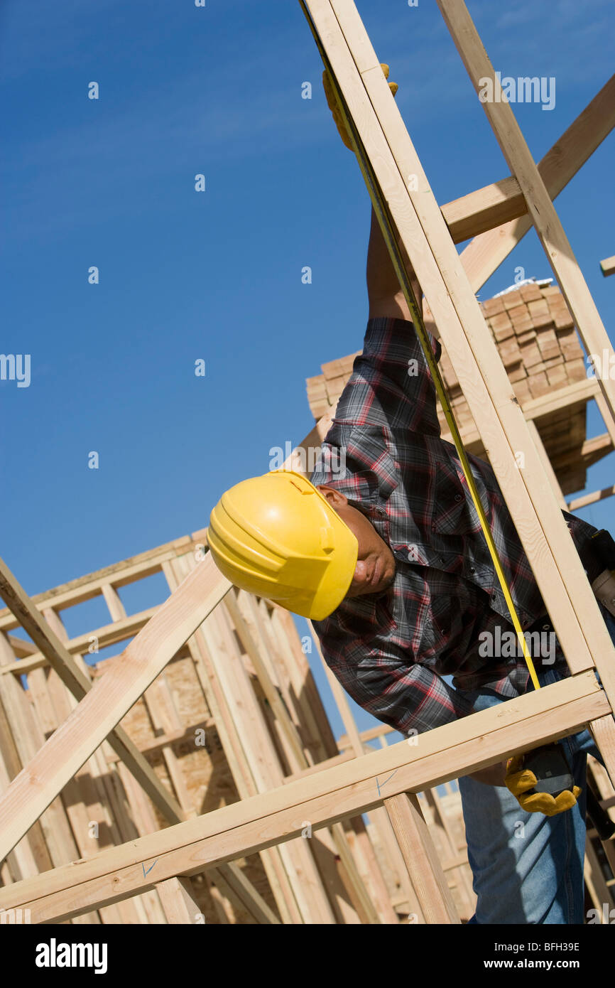 Construction worker measuring building Stock Photo - Alamy