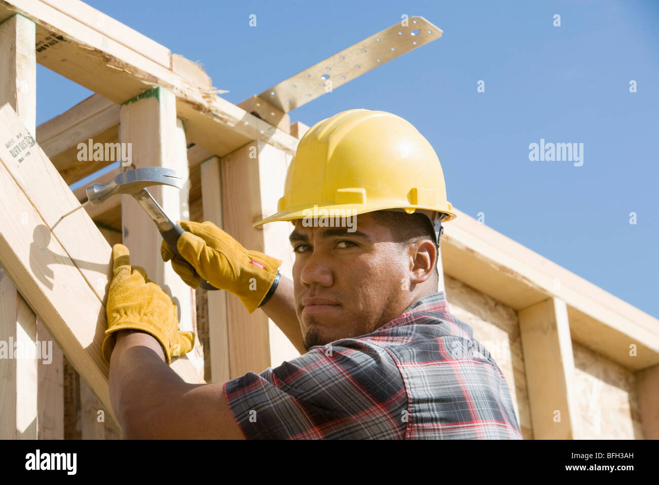 Construction worker using hammer on building Stock Photo - Alamy