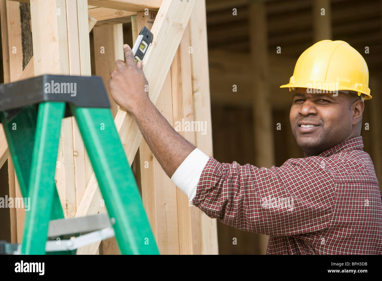 Construction worker using spirit level on building Stock Photo - Alamy