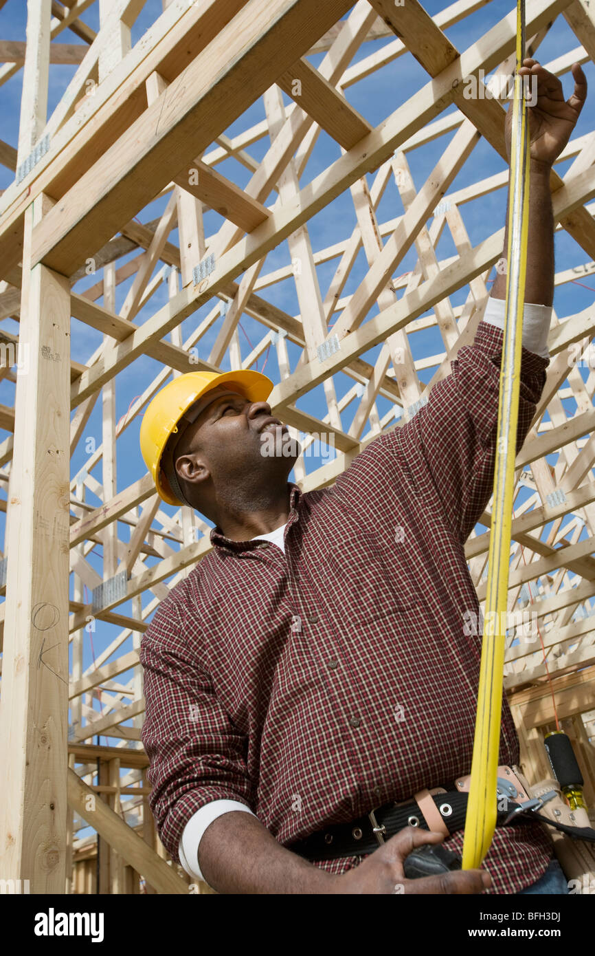 Construction worker measuring building Stock Photo - Alamy