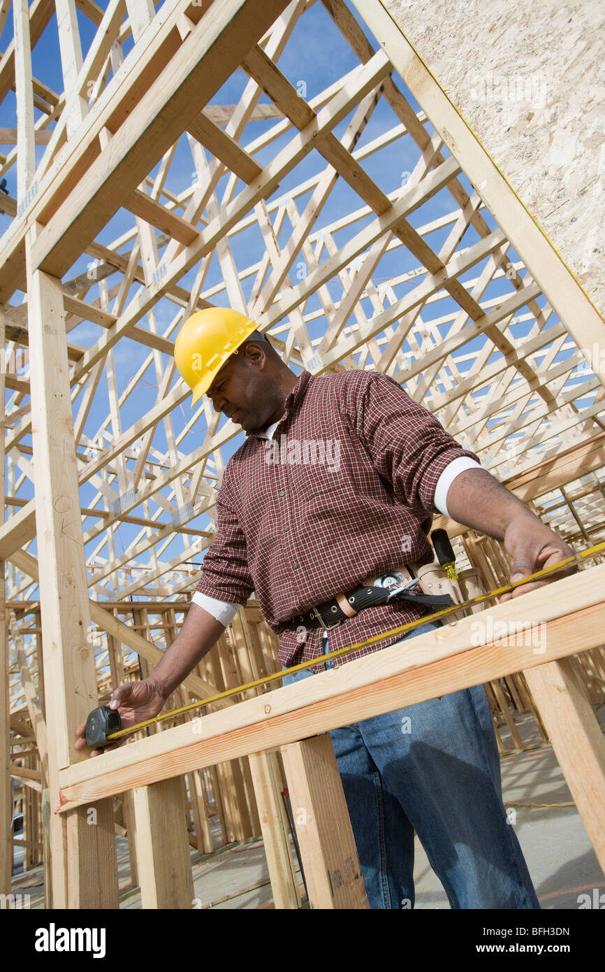 Construction worker measuring building Stock Photo - Alamy