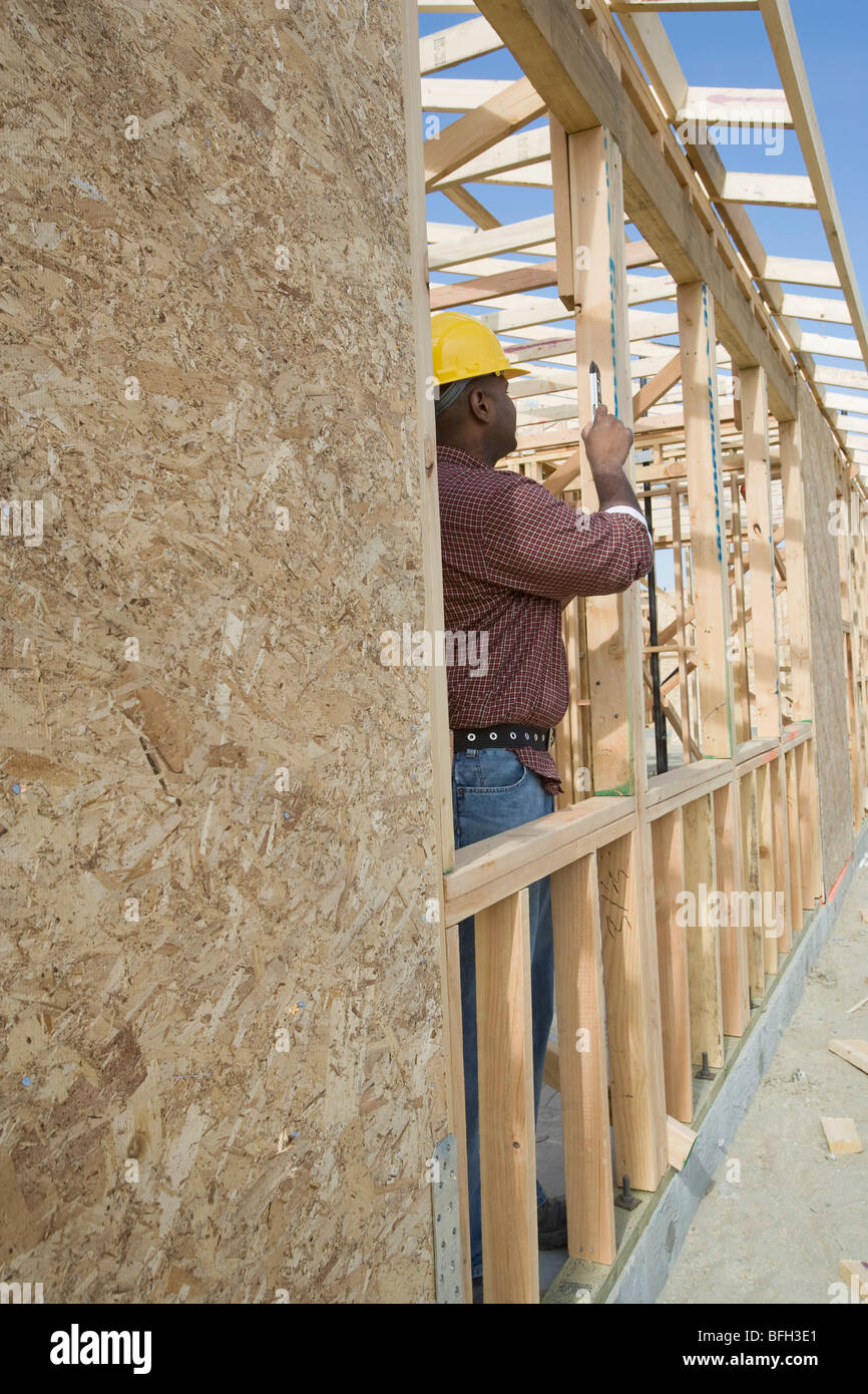 Construction worker measuring building Stock Photo - Alamy