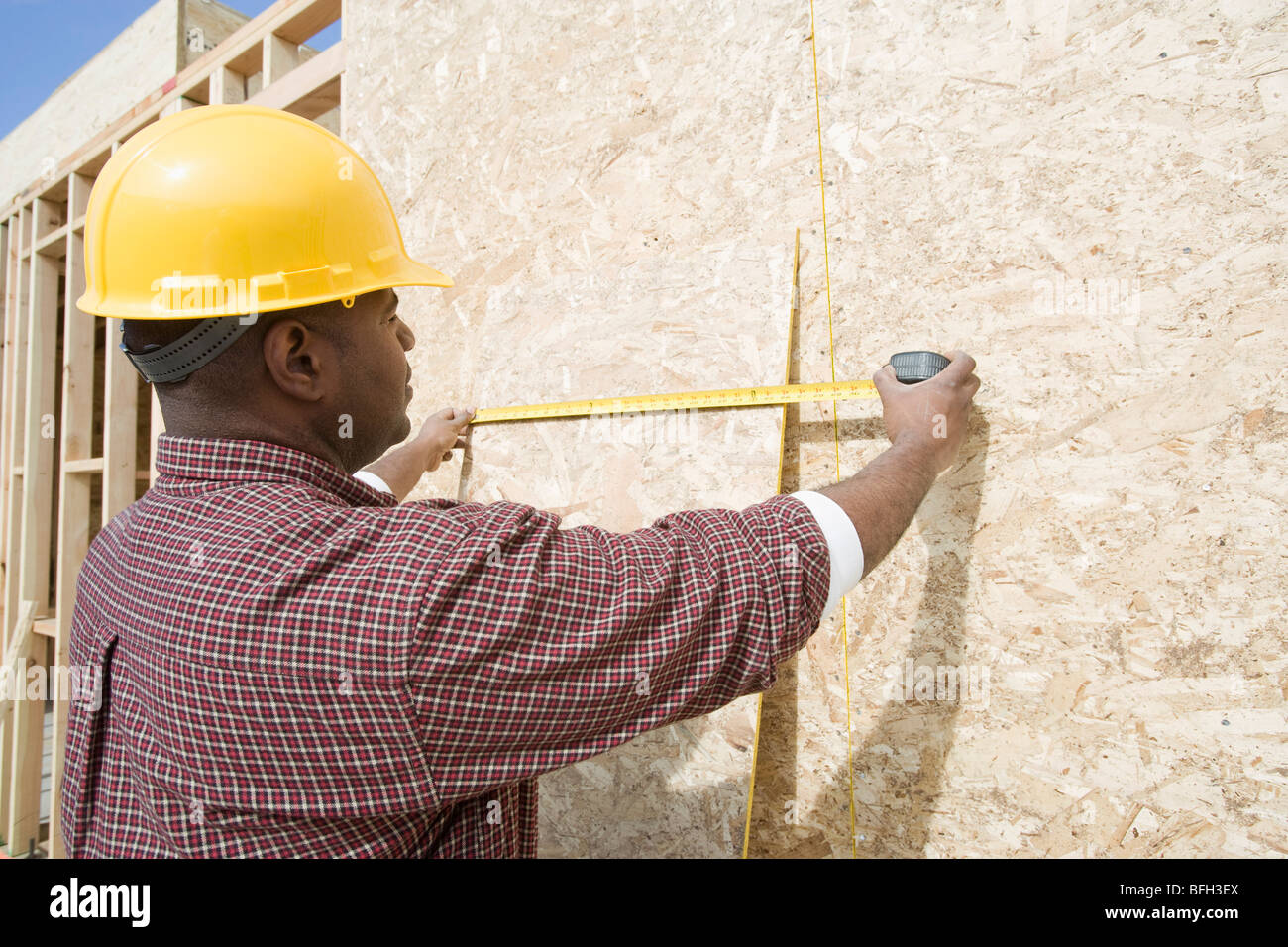 Construction worker measuring building Stock Photo - Alamy