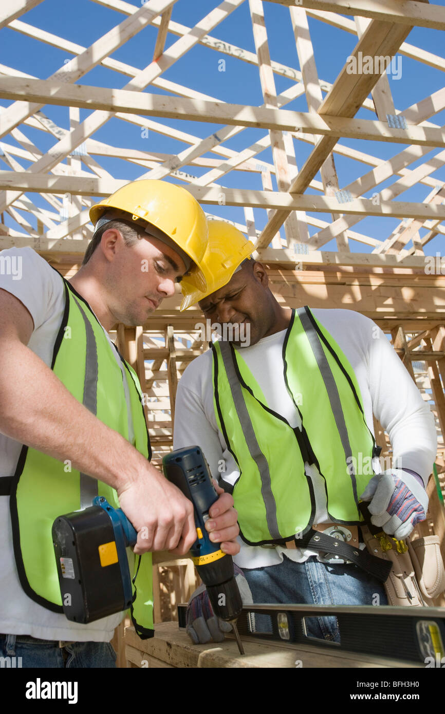 Two construction workers drilling on site Stock Photo - Alamy