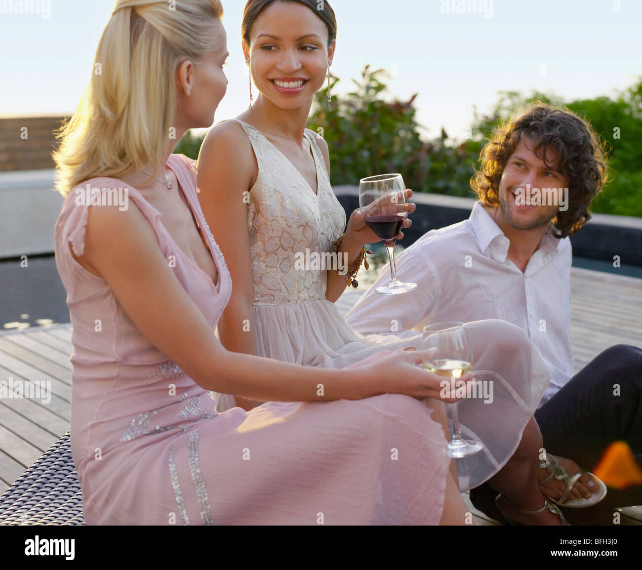 Friends sitting on porch Drinking and socialising Stock Photo - Alamy
