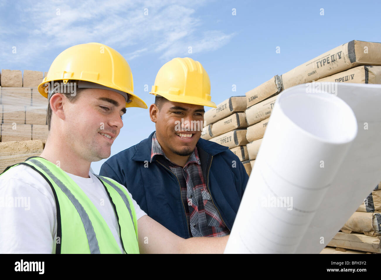 Two construction workers studying blueprints Stock Photo - Alamy