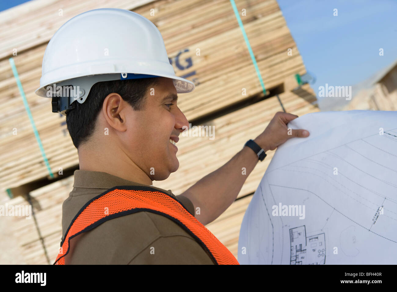 Construction worker standing on construction site and holding ...