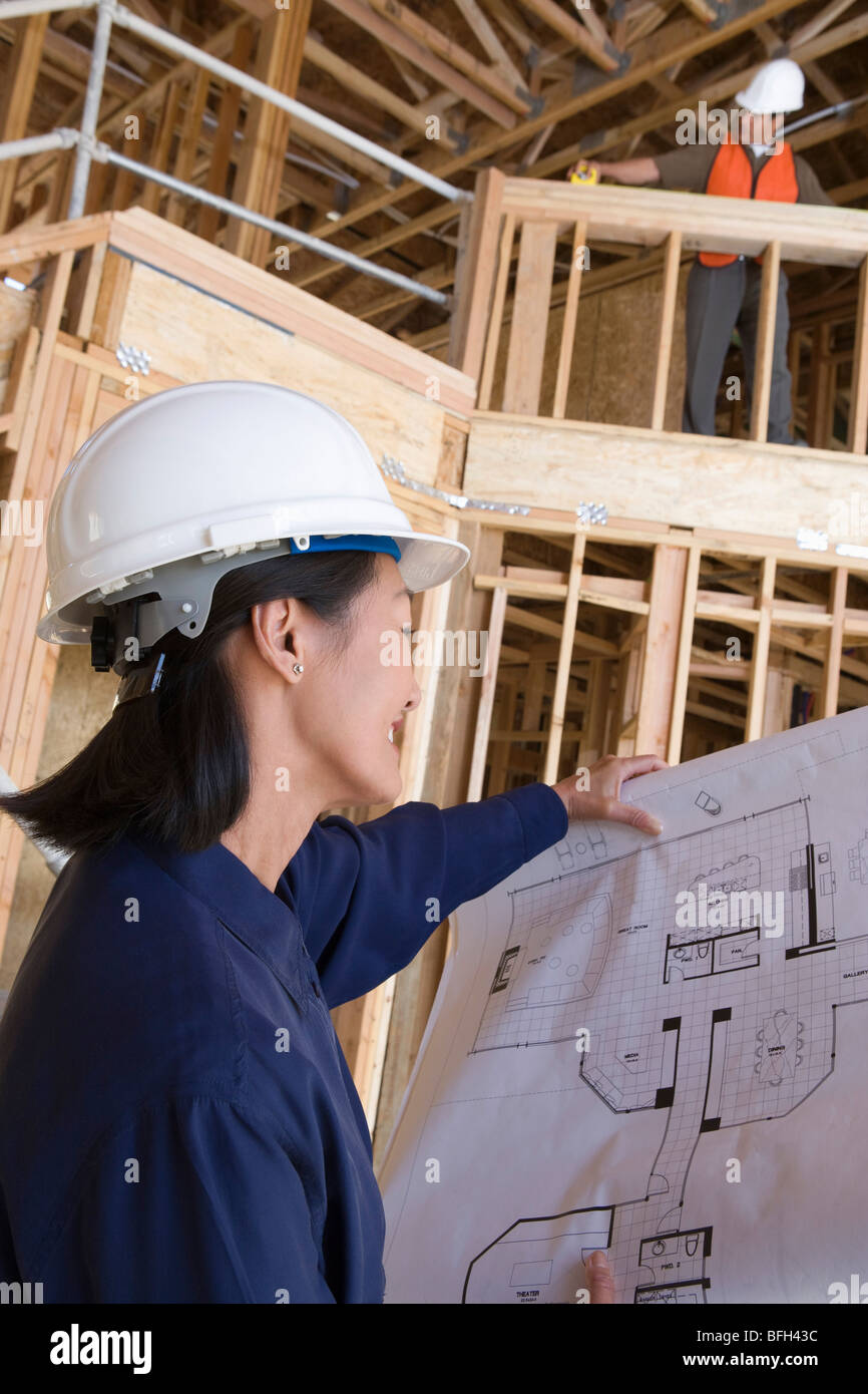Architect and construction worker examining half constructed house ...