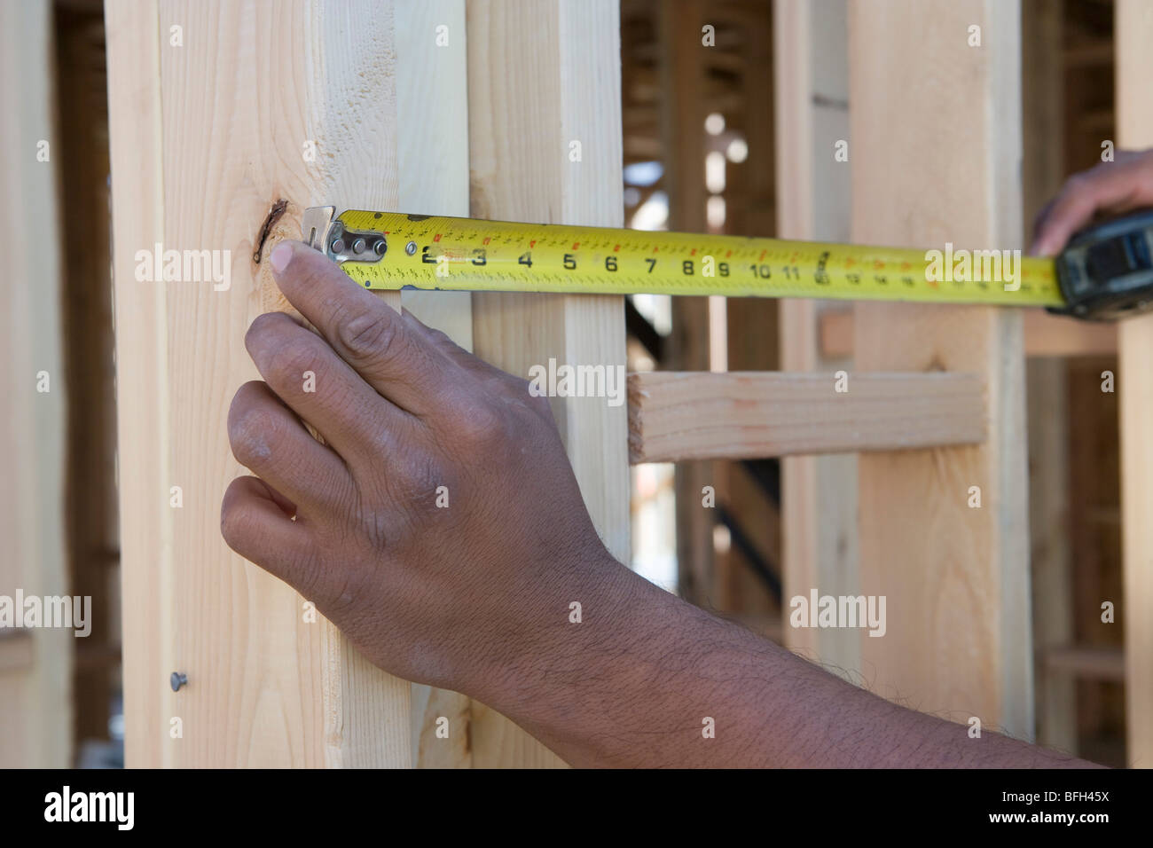 Person measuring half constructed wall with tape measure Stock Photo ...