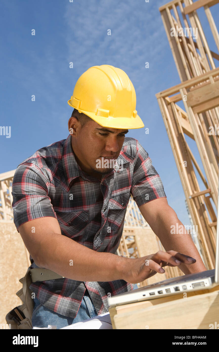 Construction worker using laptop Stock Photo - Alamy