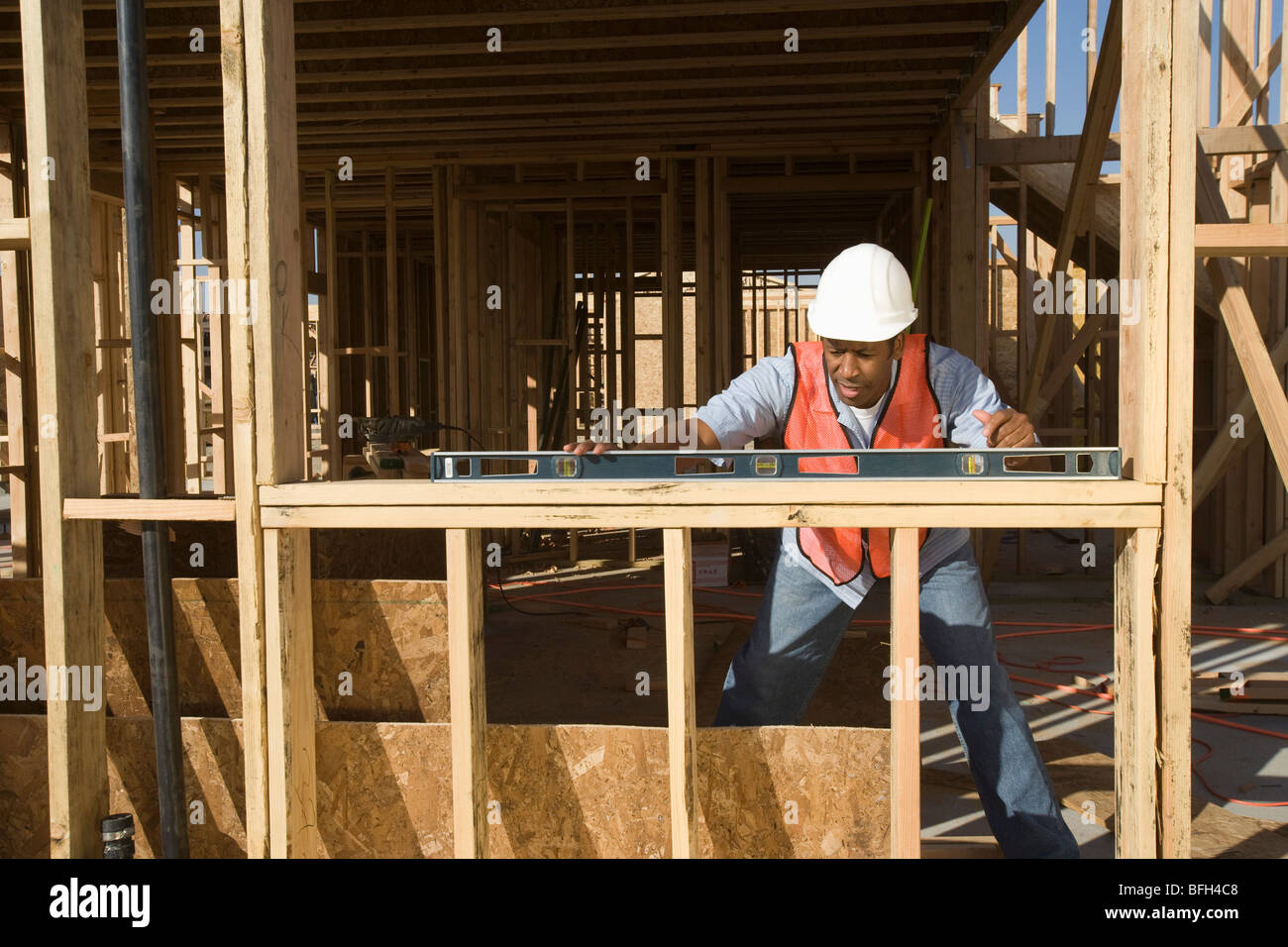Construction worker using spirit level on construction site Stock Photo ...