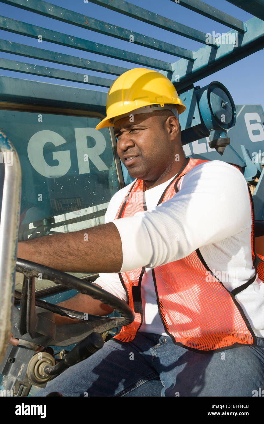 Construction worker driving vehicle Stock Photo - Alamy