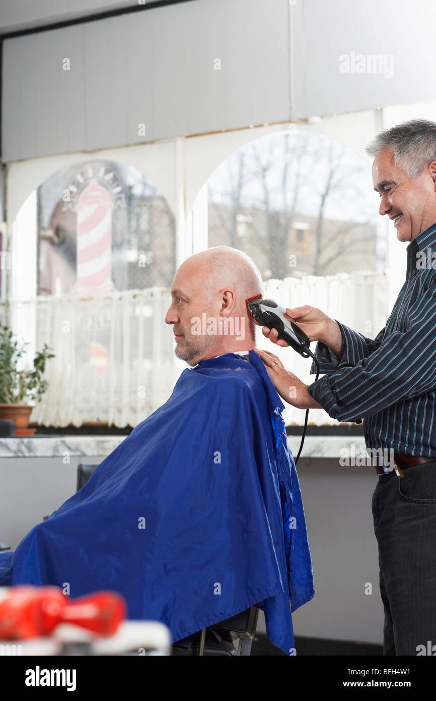 Barber shaving mans head in barber shop Stock Photo - Alamy