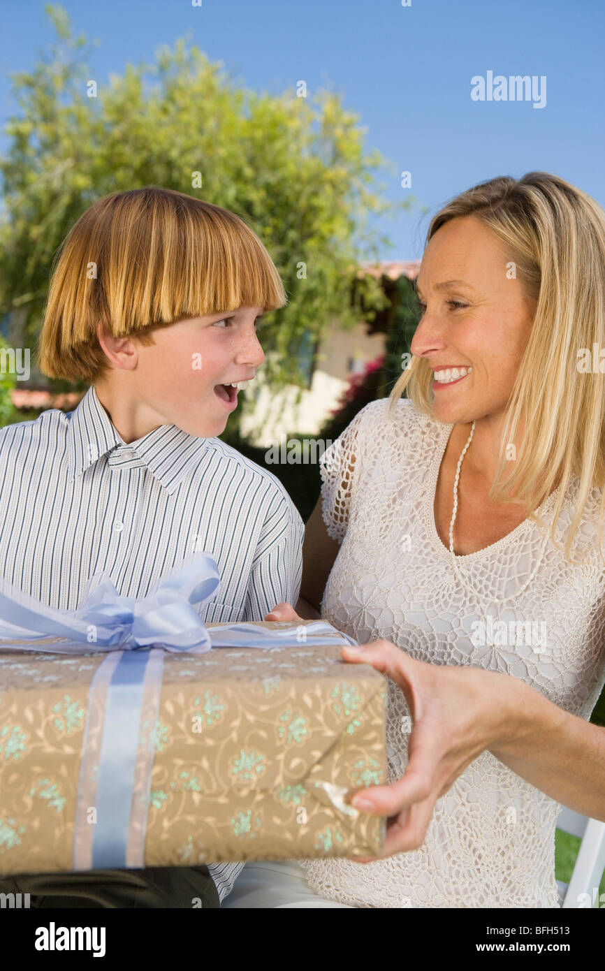 Boy giving birthday present to his mother Stock Photo - Alamy