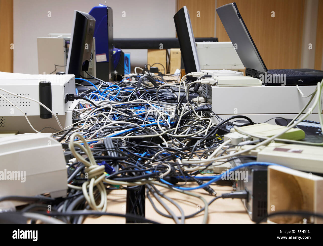 Mess of wires connecting computers and printers in office Stock Photo ...
