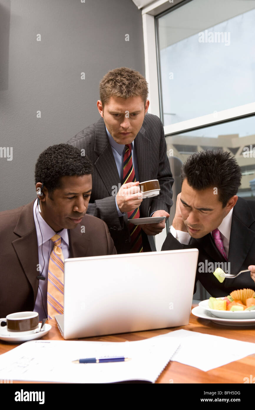 Three business men using laptop in office Stock Photo - Alamy