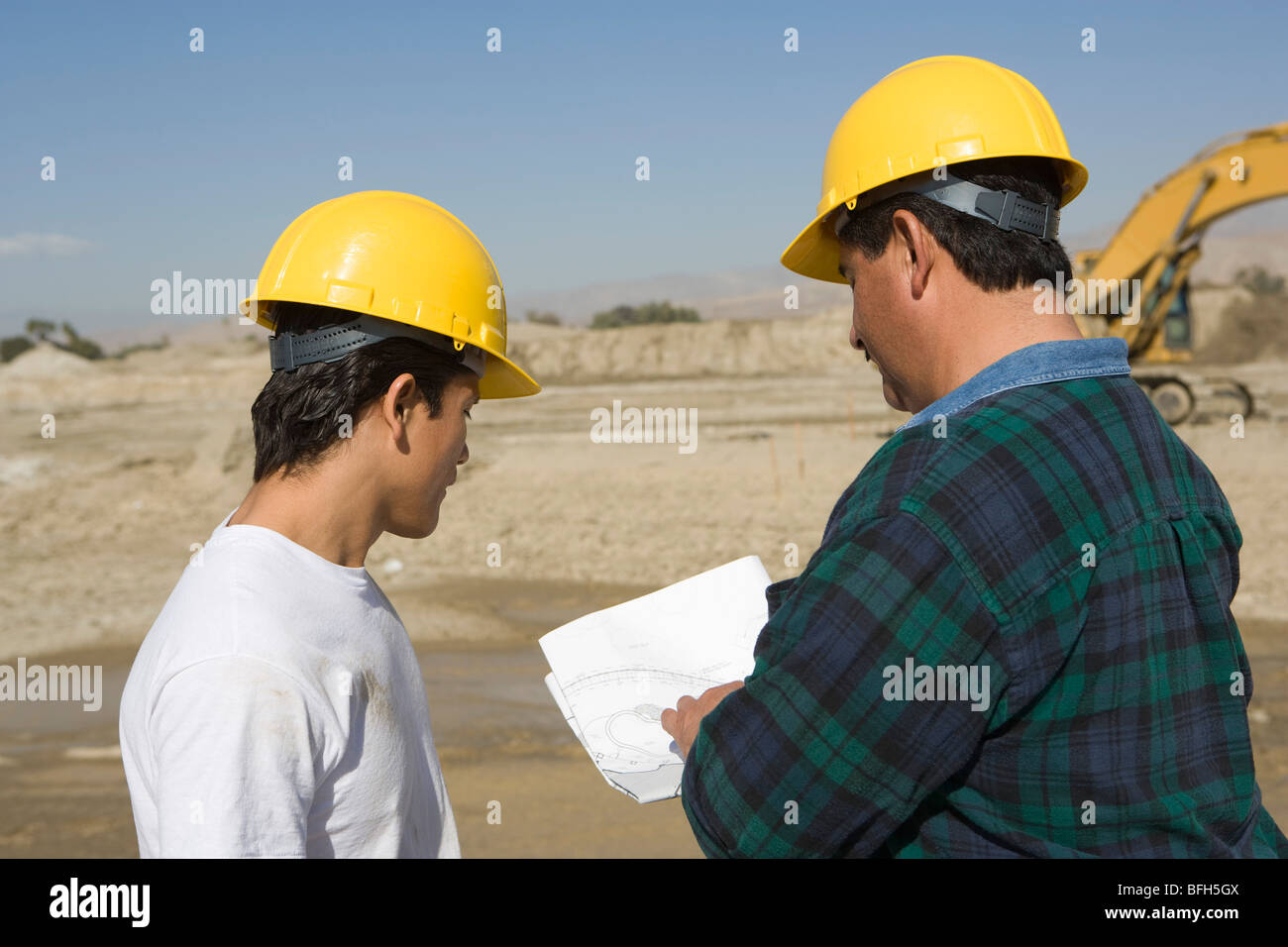 Construction Workers reading blueprint Stock Photo - Alamy