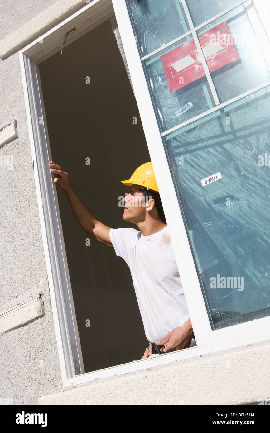 Construction Worker examining window frame Stock Photo - Alamy