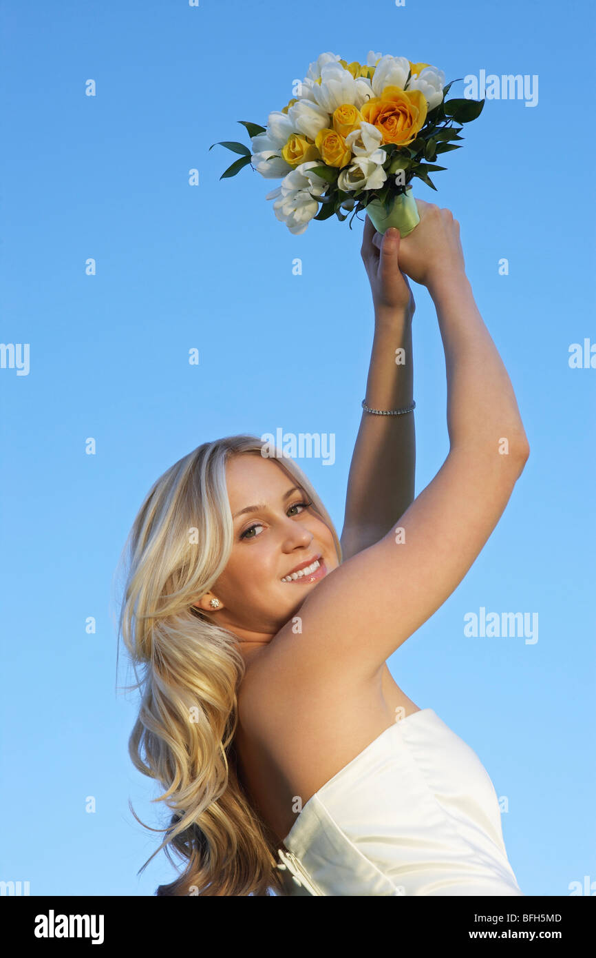 Bride holding bouquet aloft Stock Photo - Alamy