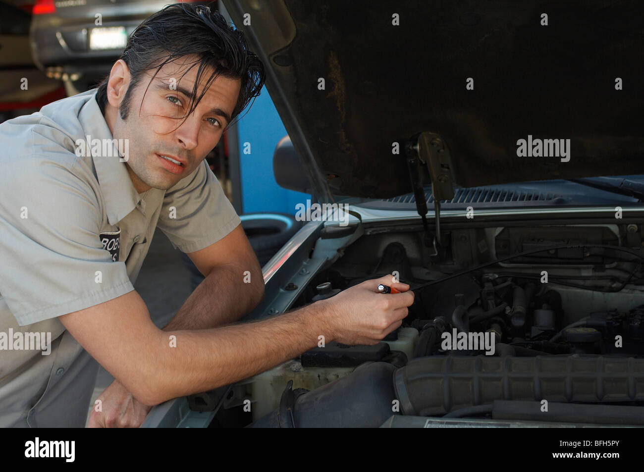 Mechanic pointing at engine, portrait Stock Photo - Alamy